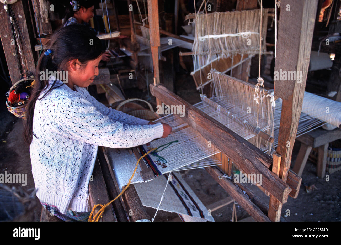 Young Maya woman sitting weaving at a treadle operated loom ...