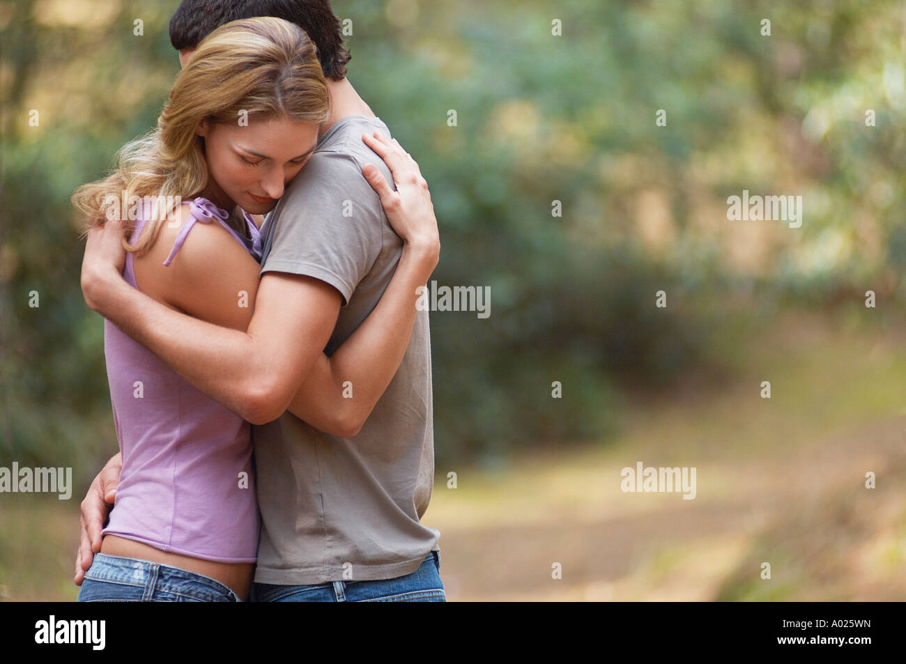 Couple standing on forest trail Hugging, side view Stock Photo - Alamy
