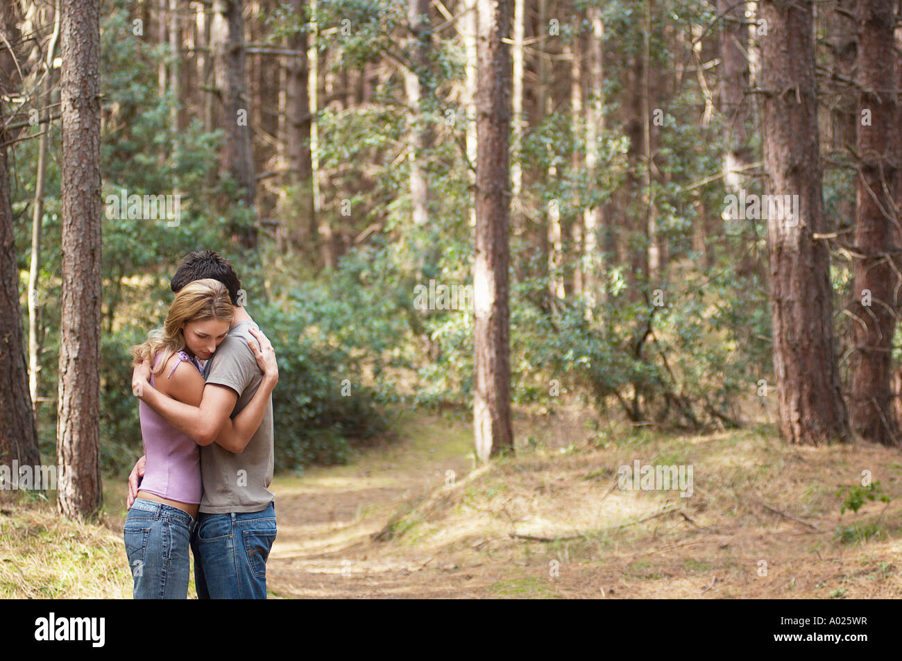 Couple standing on forest trail Hugging, side view Stock Photo - Alamy