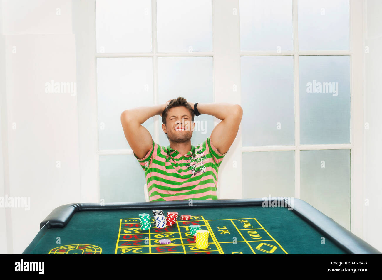 Young Man losing on roulette table Stock Photo - Alamy