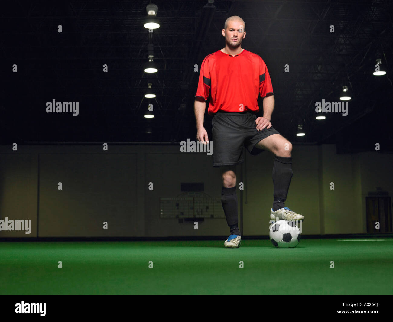 Soccer player standing on ball, portrait Stock Photo - Alamy
