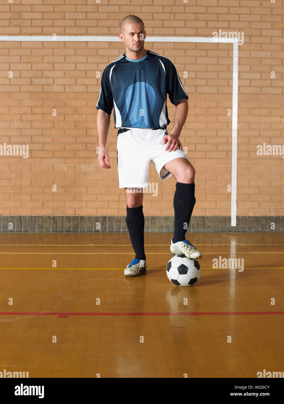 Soccer player standing on ball, portrait Stock Photo - Alamy