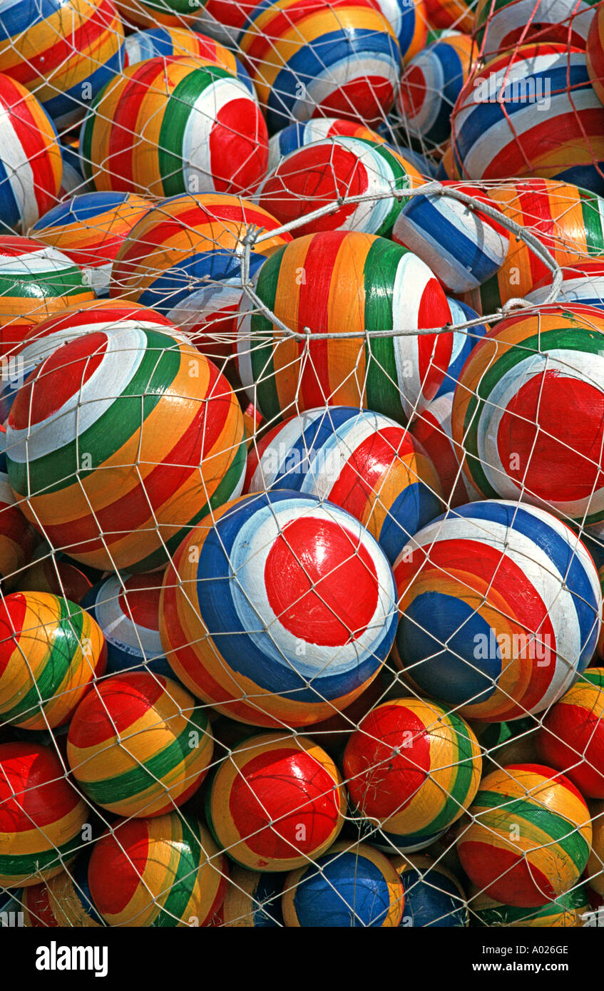 A net full of colourfully painted plastic balls being sold at market ...