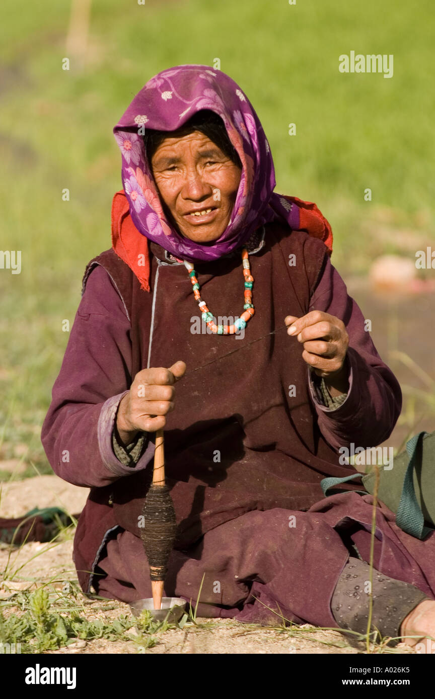 Old Ladakhi woman in traditional dress and jewellery weaving on the ...
