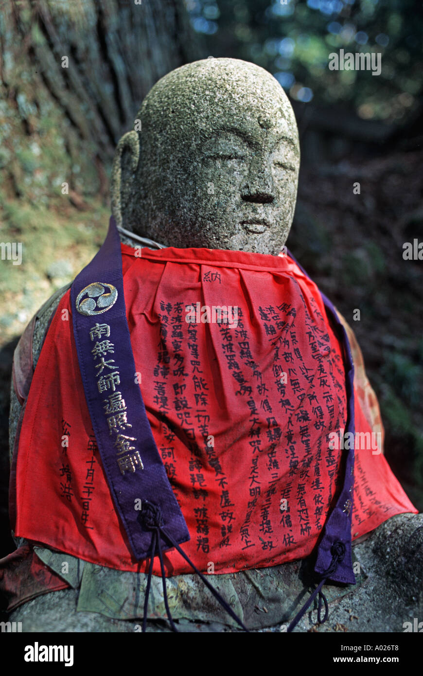 Stone jizo statue with red bib in the Okunoin the vast ancient cemetery ...