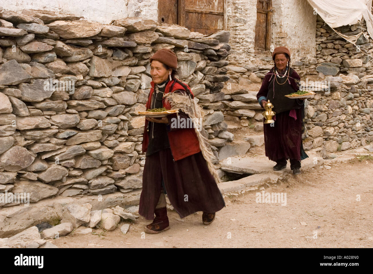 Old woman bringing food on Karsha rocky street Traditional Zanskari ...