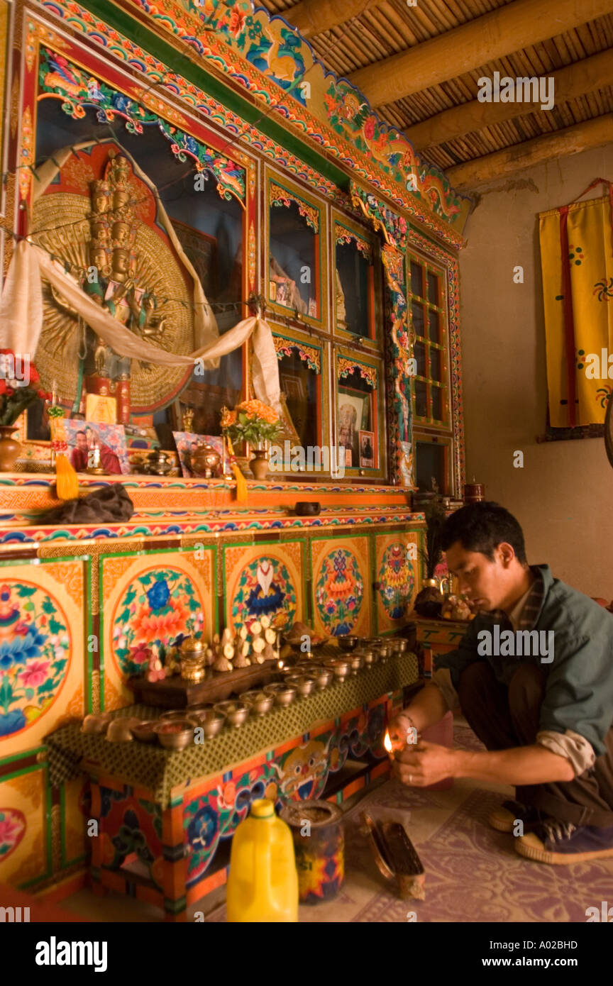 Man lighting butter lamps in traditional Ladhaki style home buddhist ...