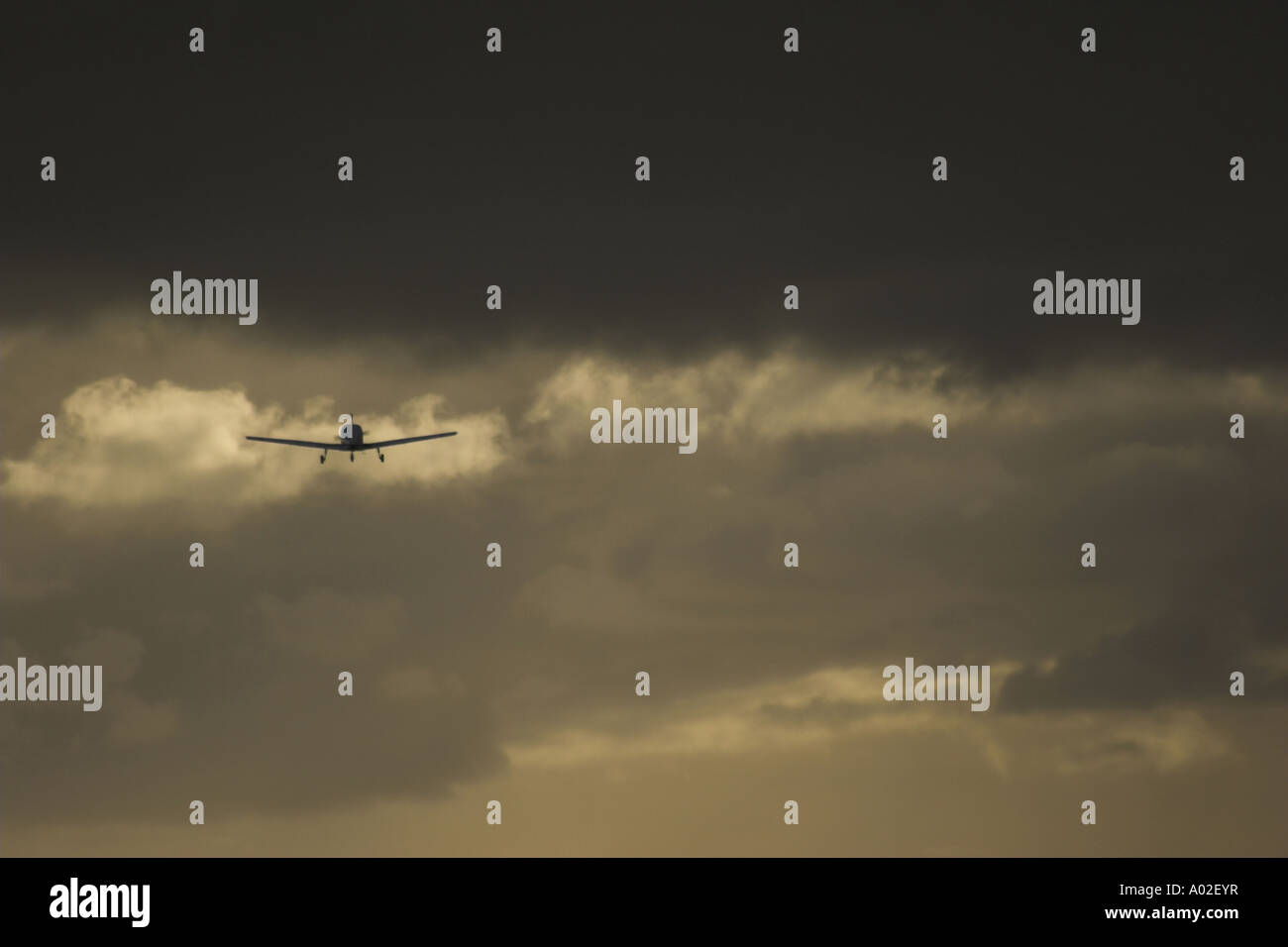 A small plane flying towards an incoming storm Stock Photo - Alamy