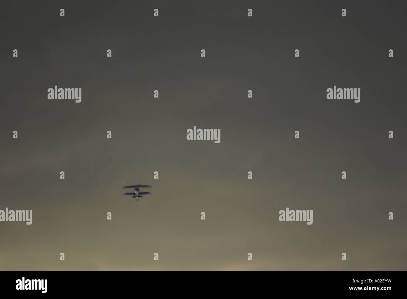 A small biplane flying towards an incoming storm Stock Photo - Alamy