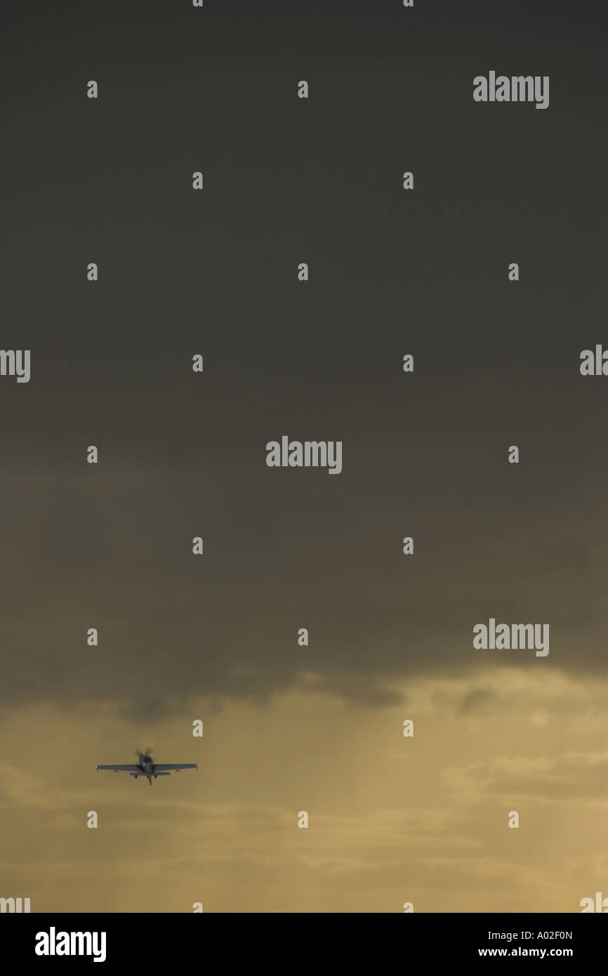 A small plane flying towards an incoming storm Stock Photo - Alamy