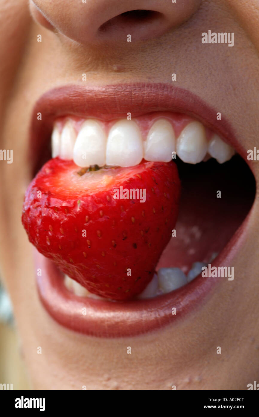 An attractive teenager enjoying a strawberry Healthy eating Stock Photo ...