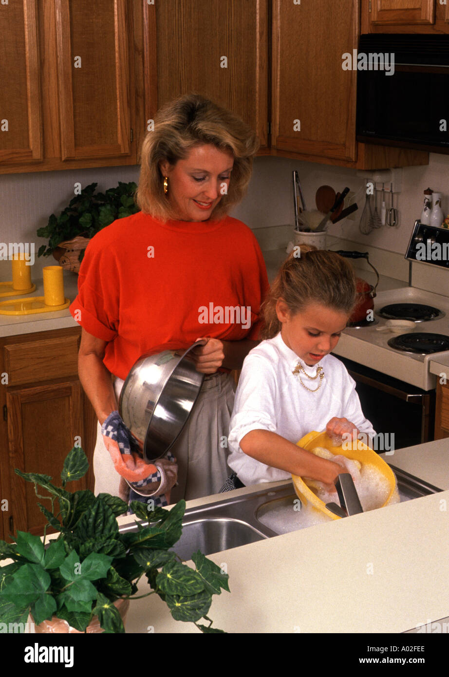 Beautiful mother and daughter washing dishes Stock Photo - Alamy