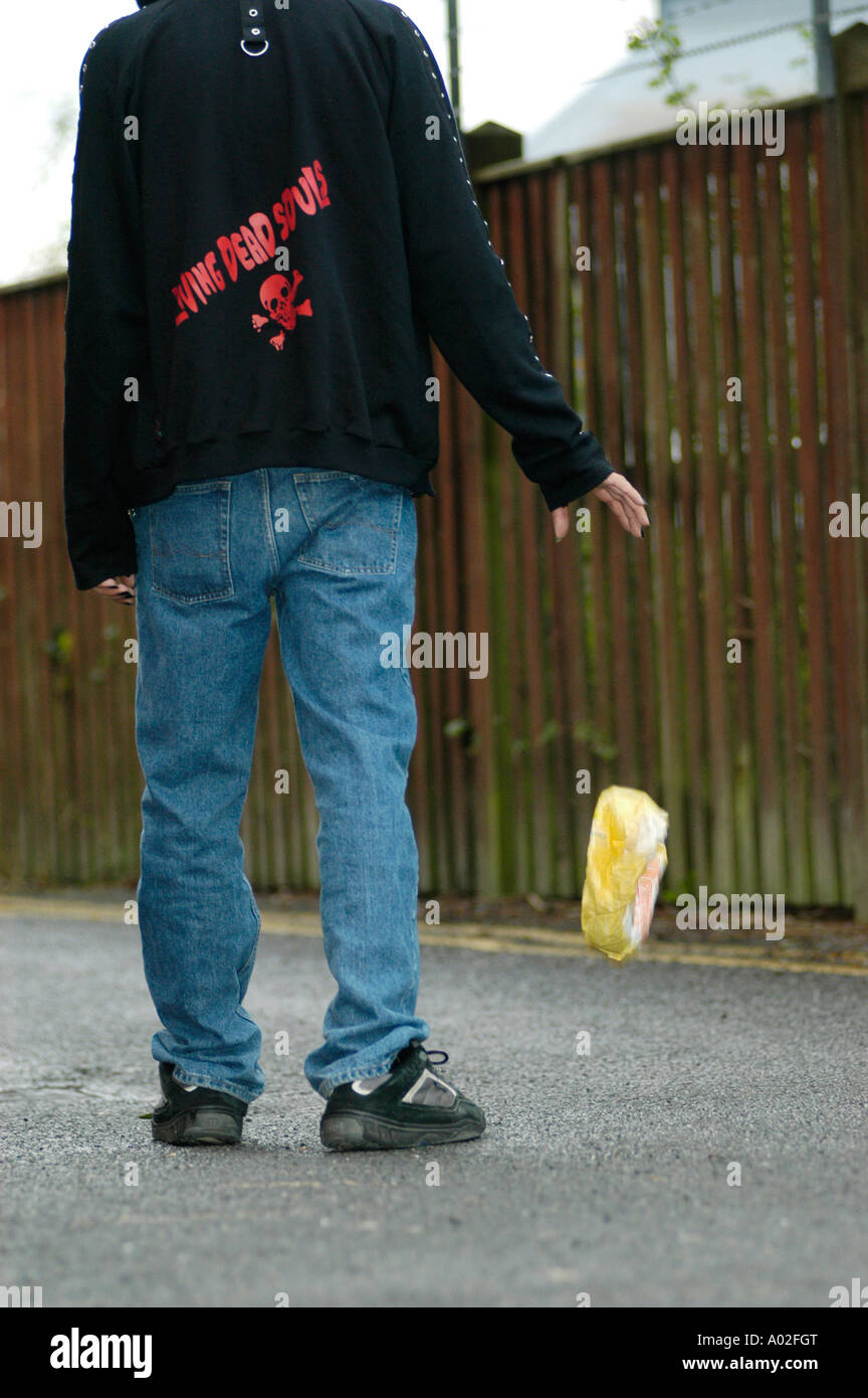 Youth dropping litter on a street in the uk Stock Photo - Alamy