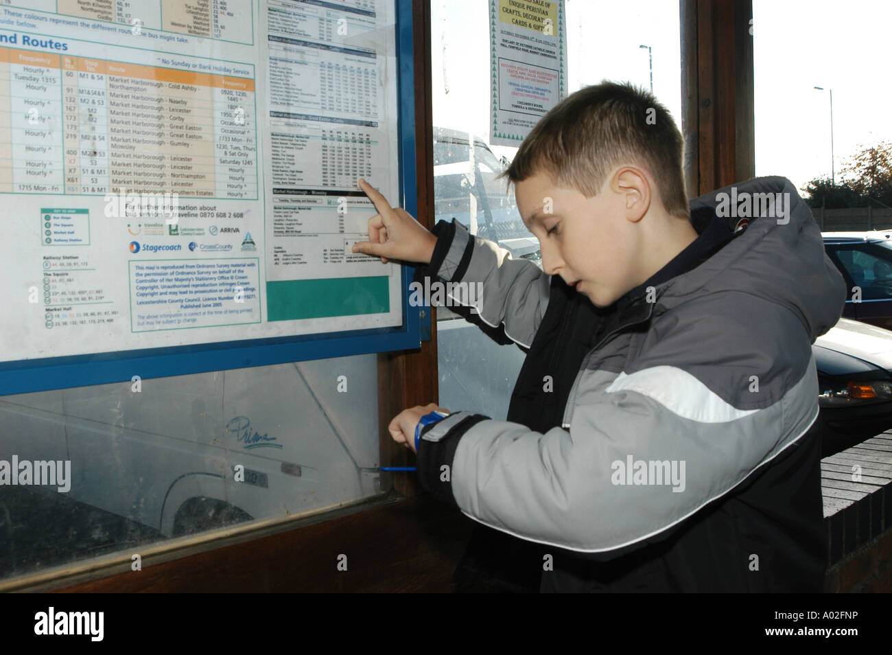 boy checking timetable at bus stop in the uk Stock Photo - Alamy