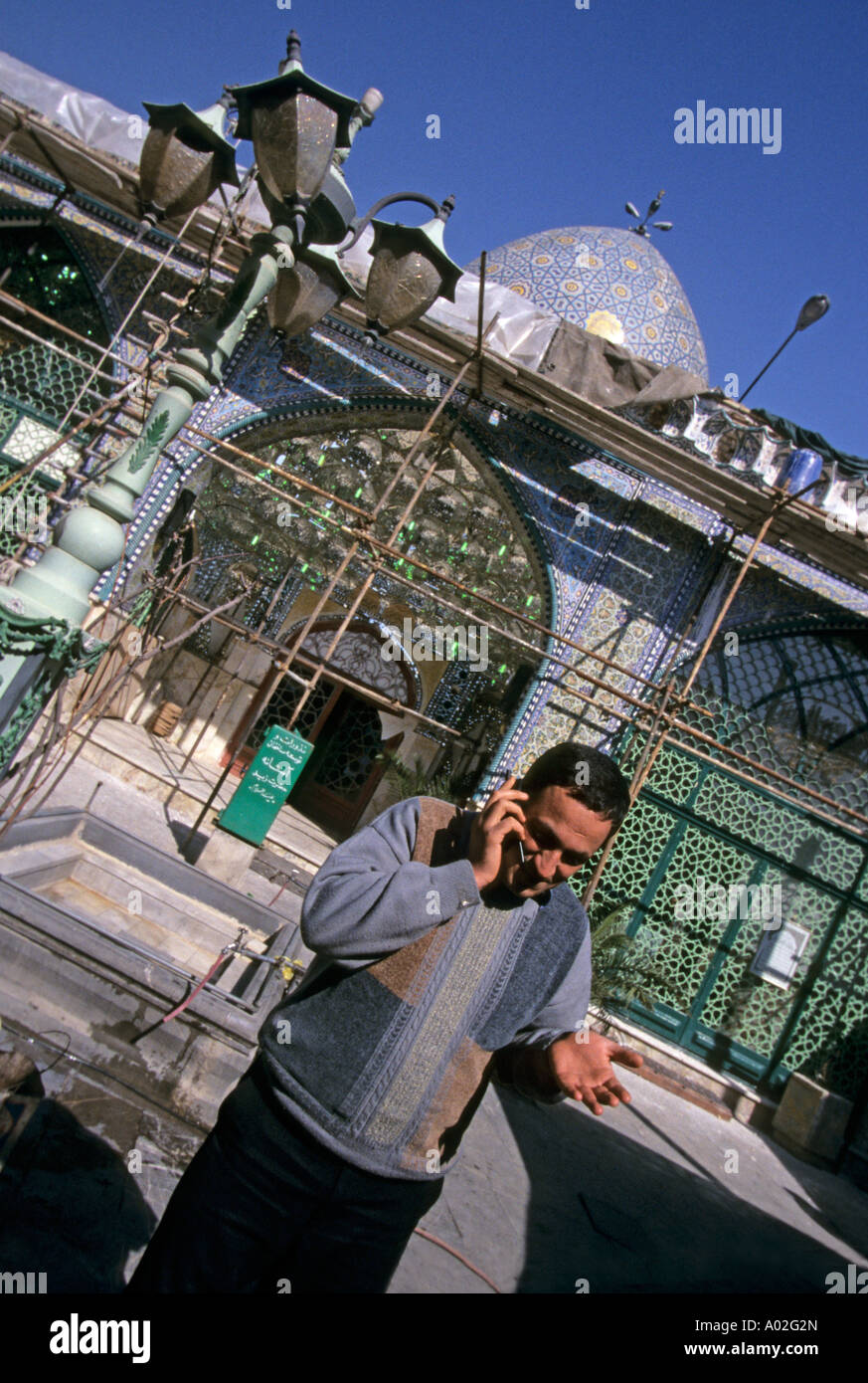 Man using mobile phone in front of mosque undergoing restoration in ...