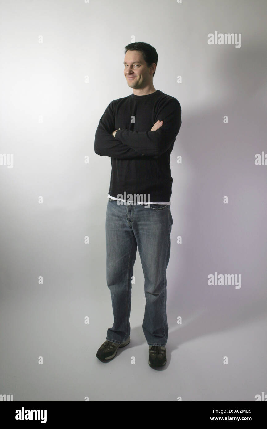 Man stood upright proud and confident with arms folded looking straight ...