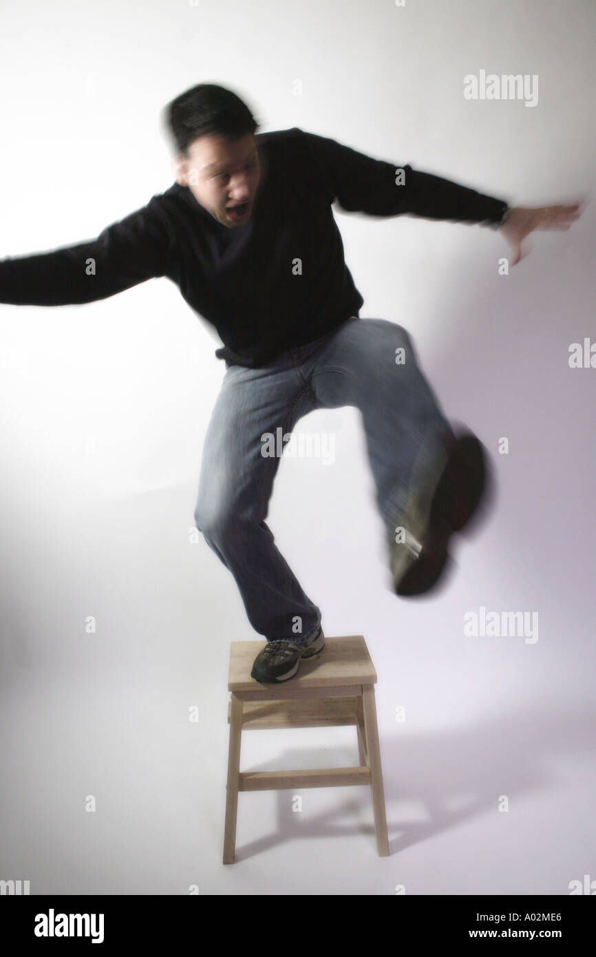 Man stood on stool losing his balance and about to fall over Stock ...