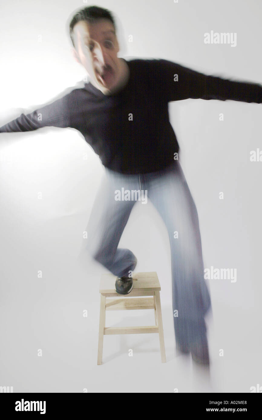 Man stood on stool losing his balance and about to fall over Stock ...