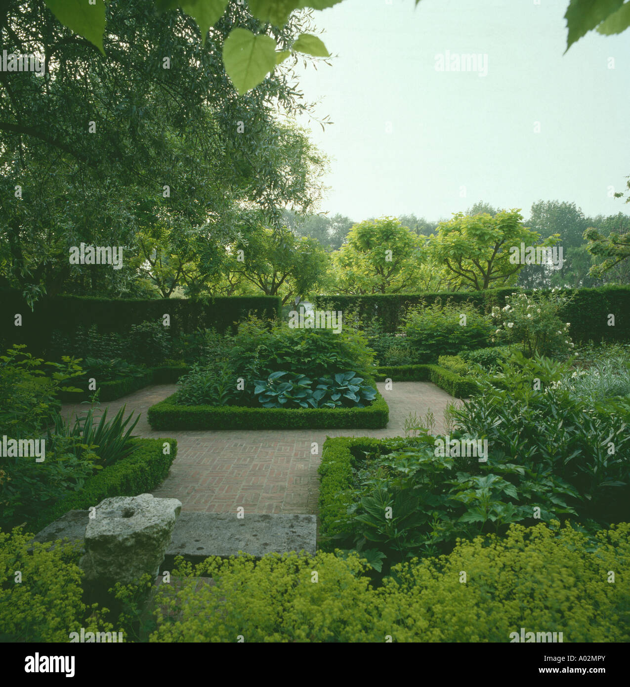 Formal garden beds with paving and clipped box edging in large country ...