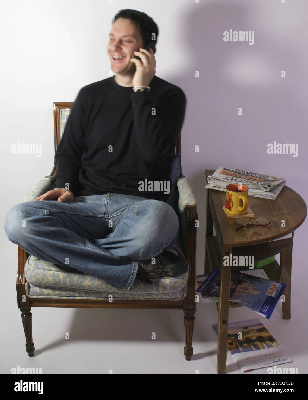 Man sat down talking on his mobile phone laughing having fun Stock ...