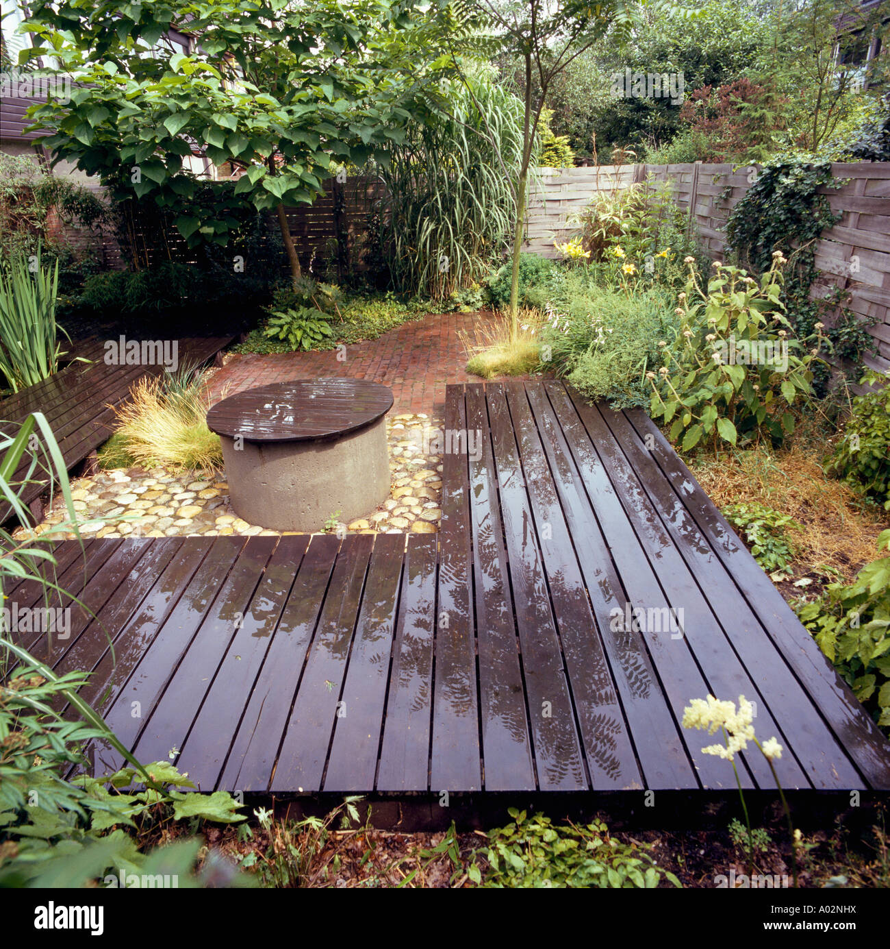 Table on cobbles beside decking after rain in a town garden Stock Photo ...