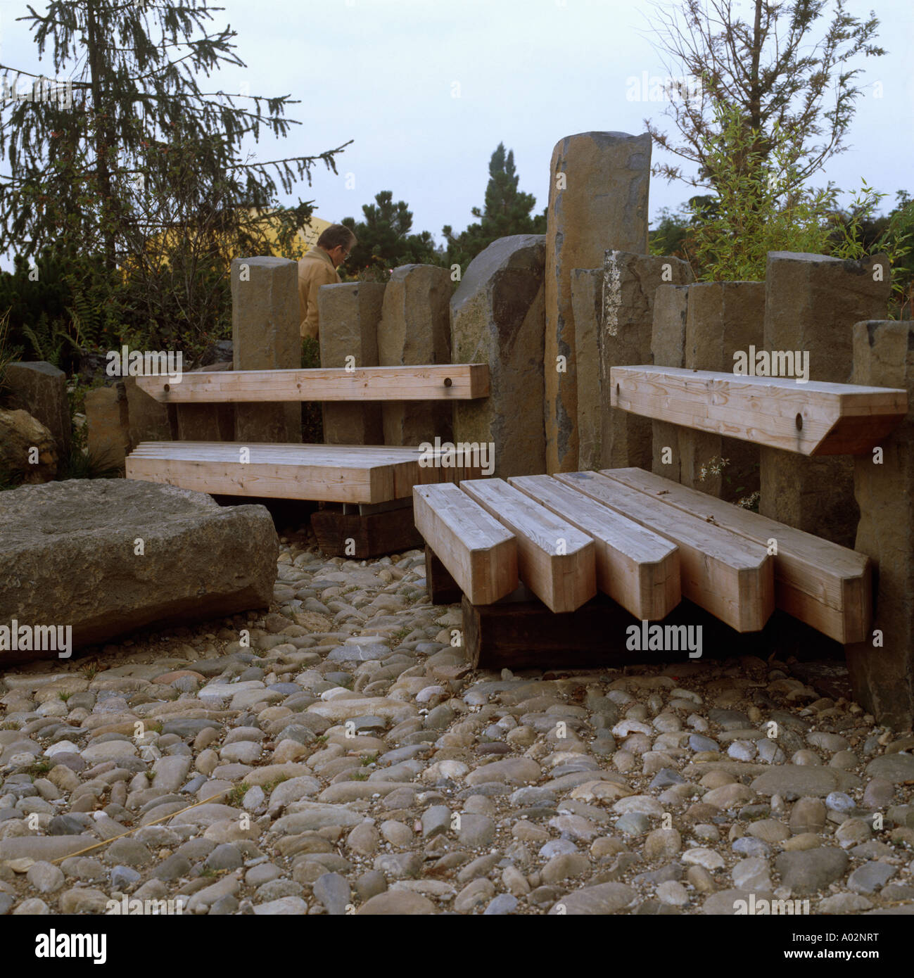 Wooden sleeper fencing with integral built-in seating on cobble paving ...