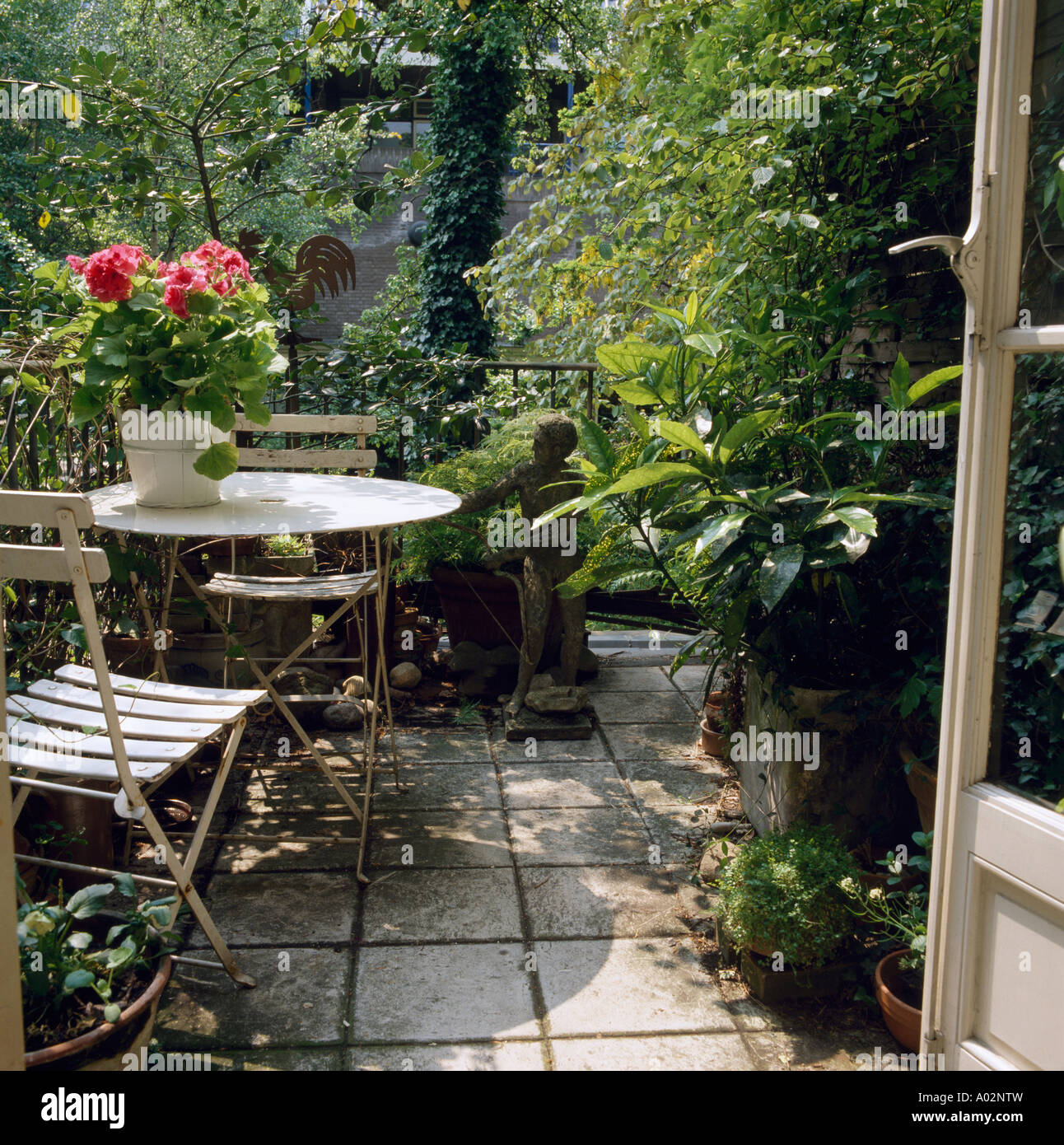 View from inside through garden doors to small paved patio with metal ...