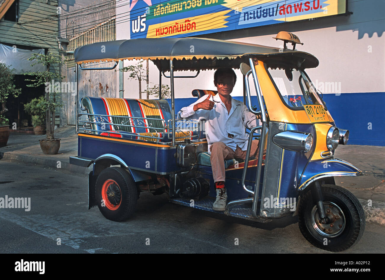 Friendly driver of a motorised rickshaw or tuk tuk giving a thumbs up ...
