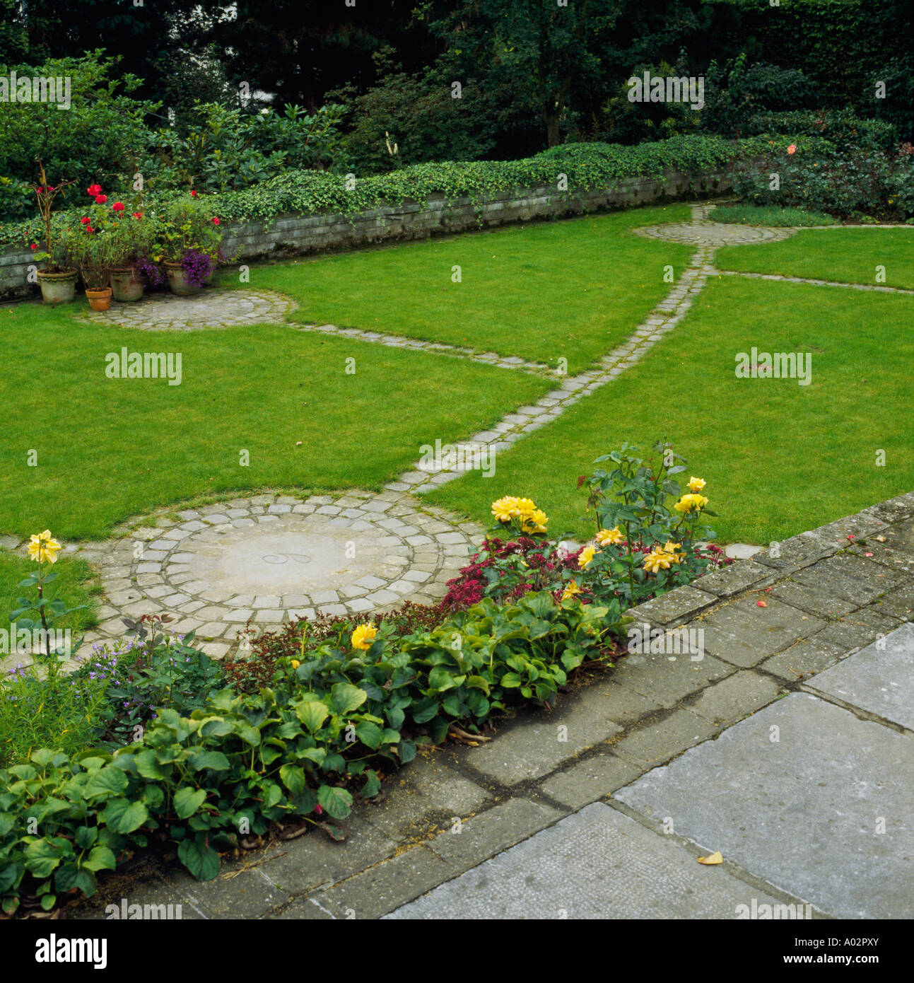 Paths to circular paving across lawn Stock Photo - Alamy
