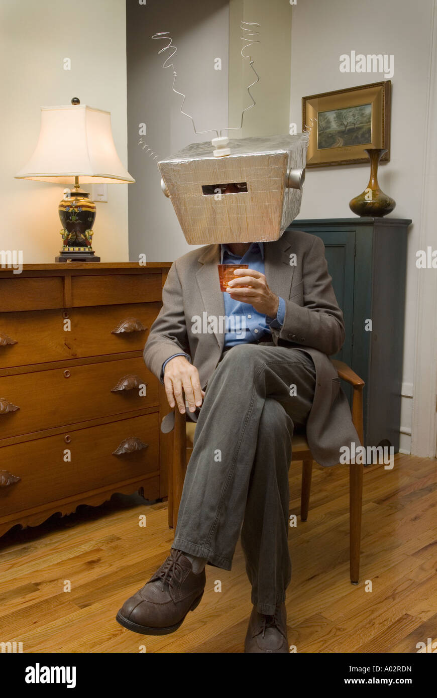 man wearing communications box on head with antennas seated in home ...