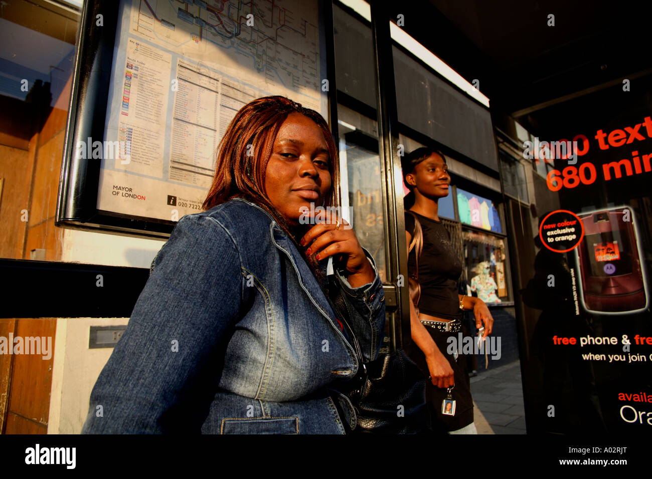 Women waiting at bus-stop in North London Stock Photo - Alamy