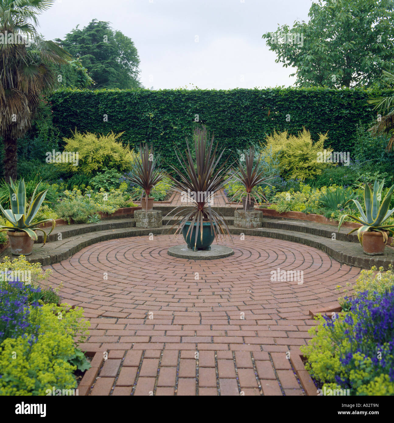 Cicular brick terrace with pots of phormium and agave Stock Photo - Alamy