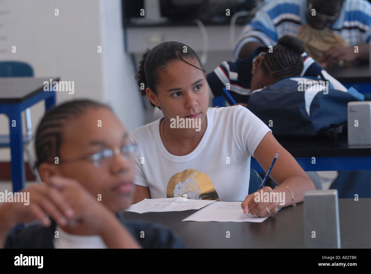 Hispanic student with pencil at desk in a classroom setting Stock Photo ...