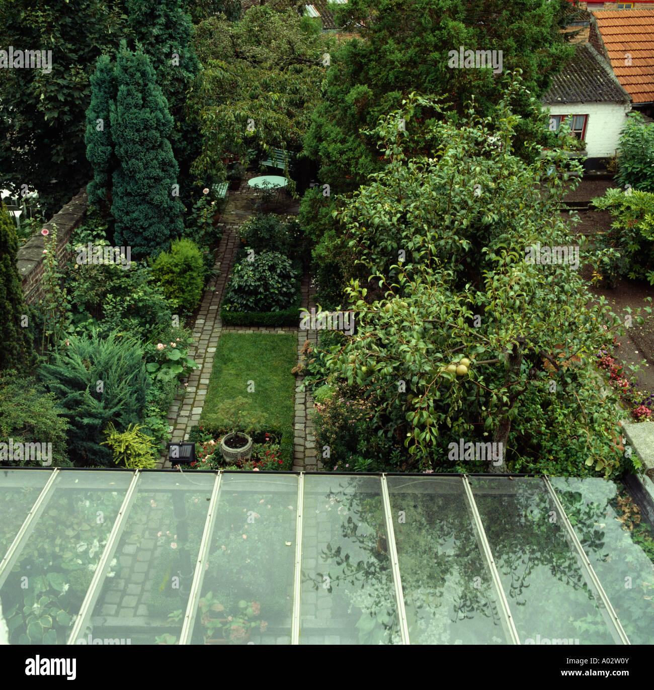 Birds-eye view over glass conservatory roof to town garden with small ...