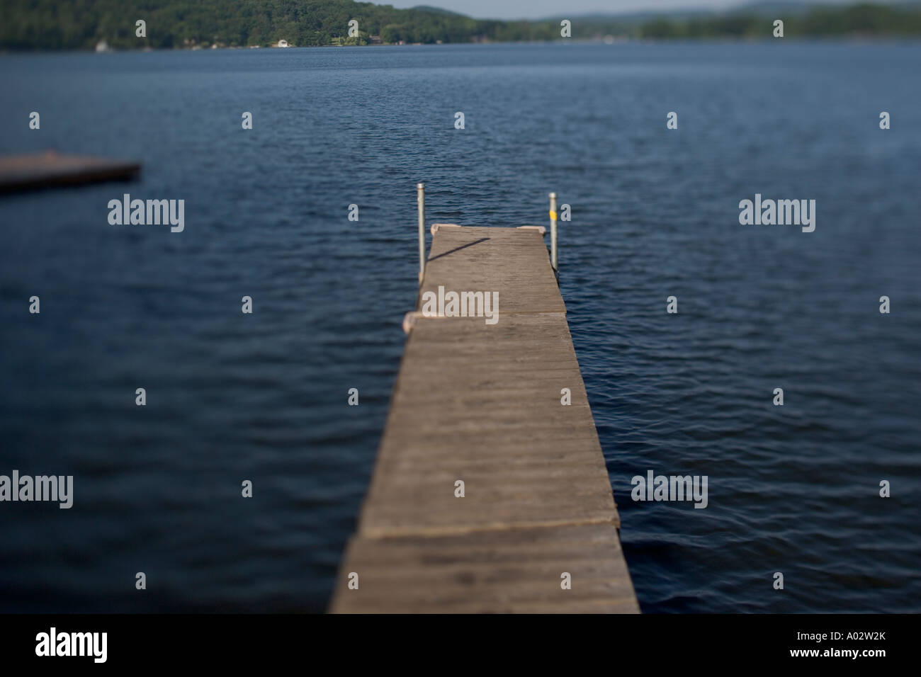 A dock running out into a clear blue lake Stock Photo - Alamy