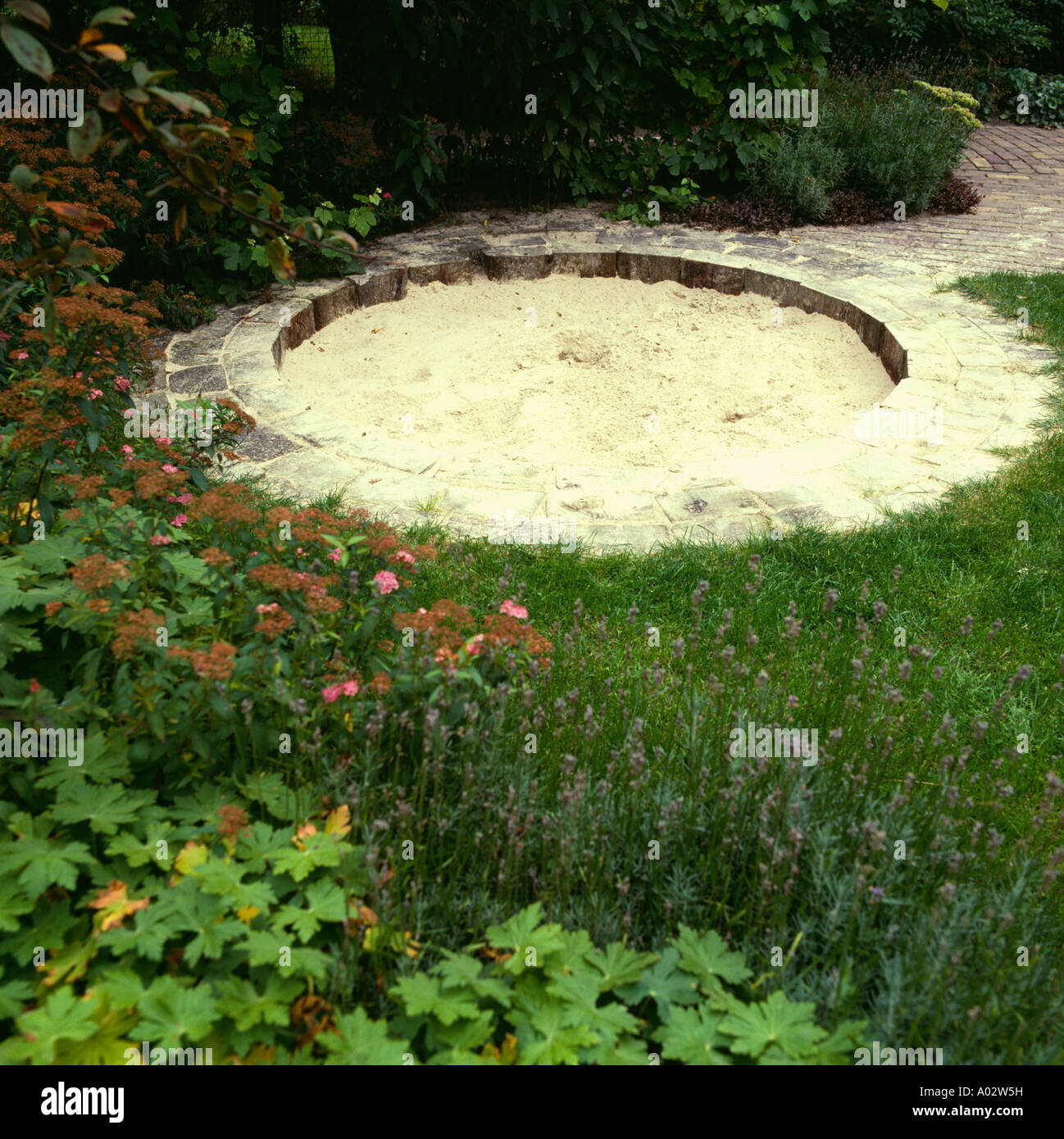 Brick-edged circular sandpit in children's garden Stock Photo - Alamy