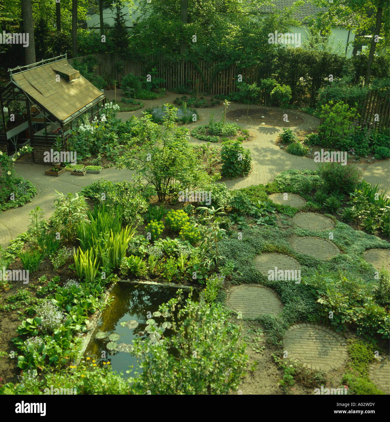 Aerial view of paved country garden with shed and pond and circular ...