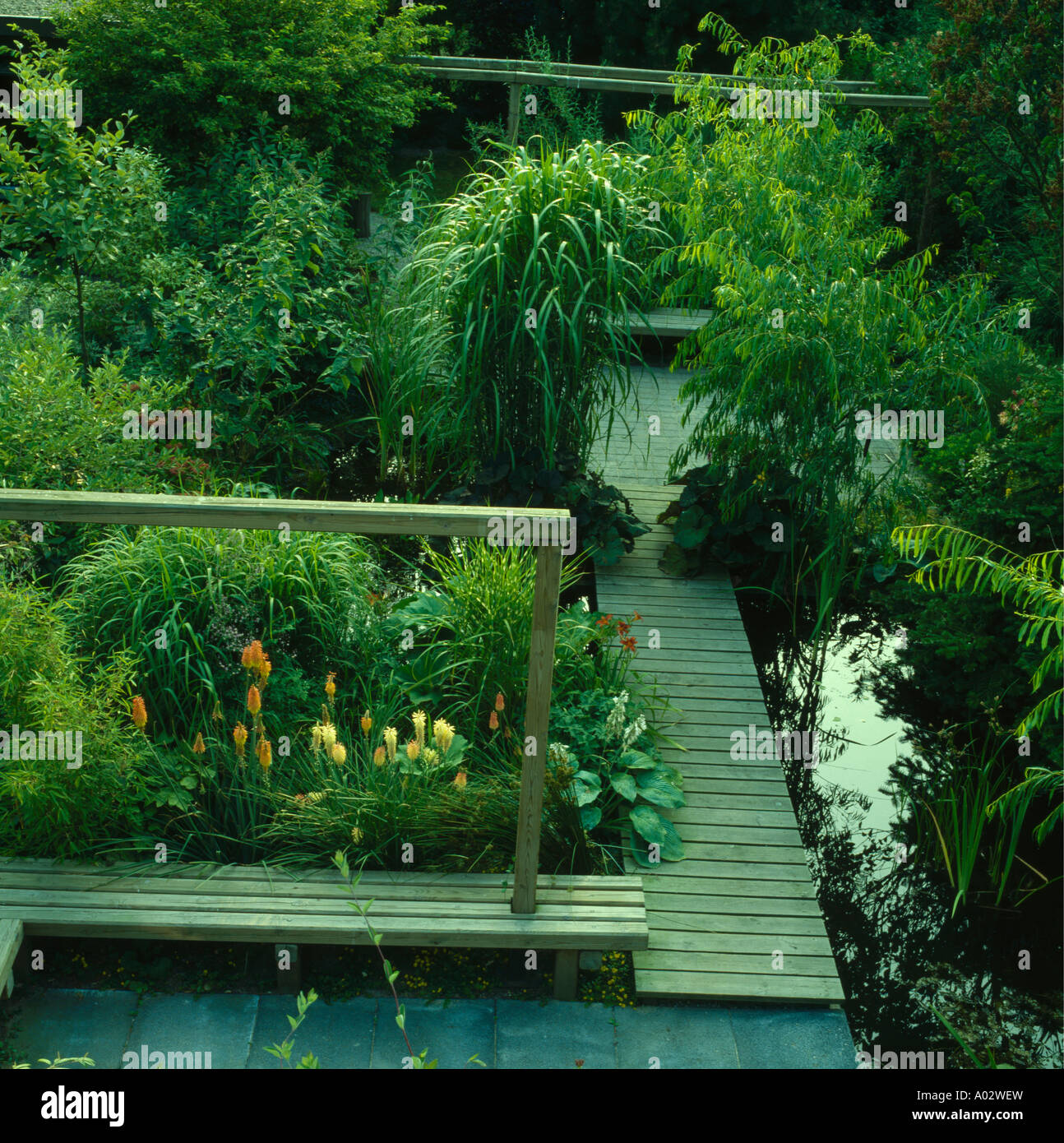 Aerial view of decking paths between formal ponds and lush planting ...