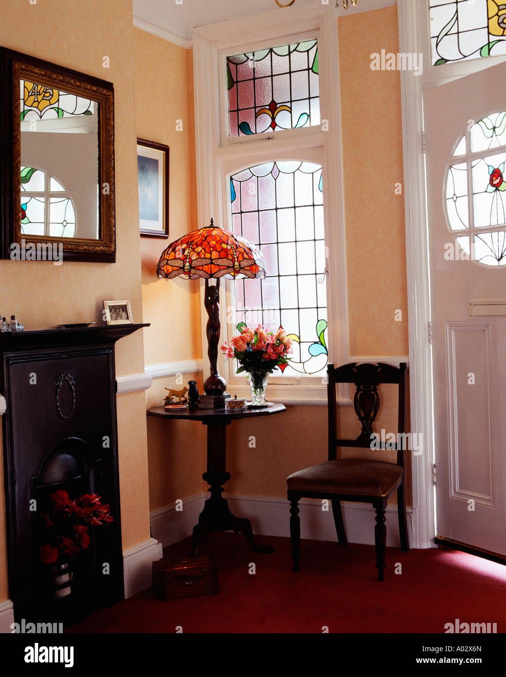 Stained glass windows and door in traditional hall with fireplace and ...