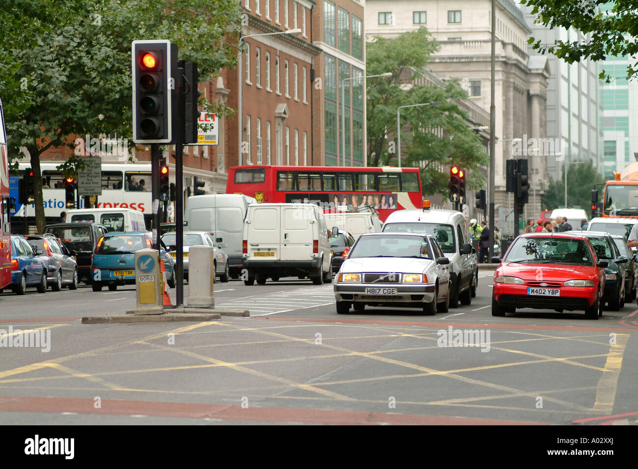 Traffic waiting at red traffic lights by a box junction in the city of ...