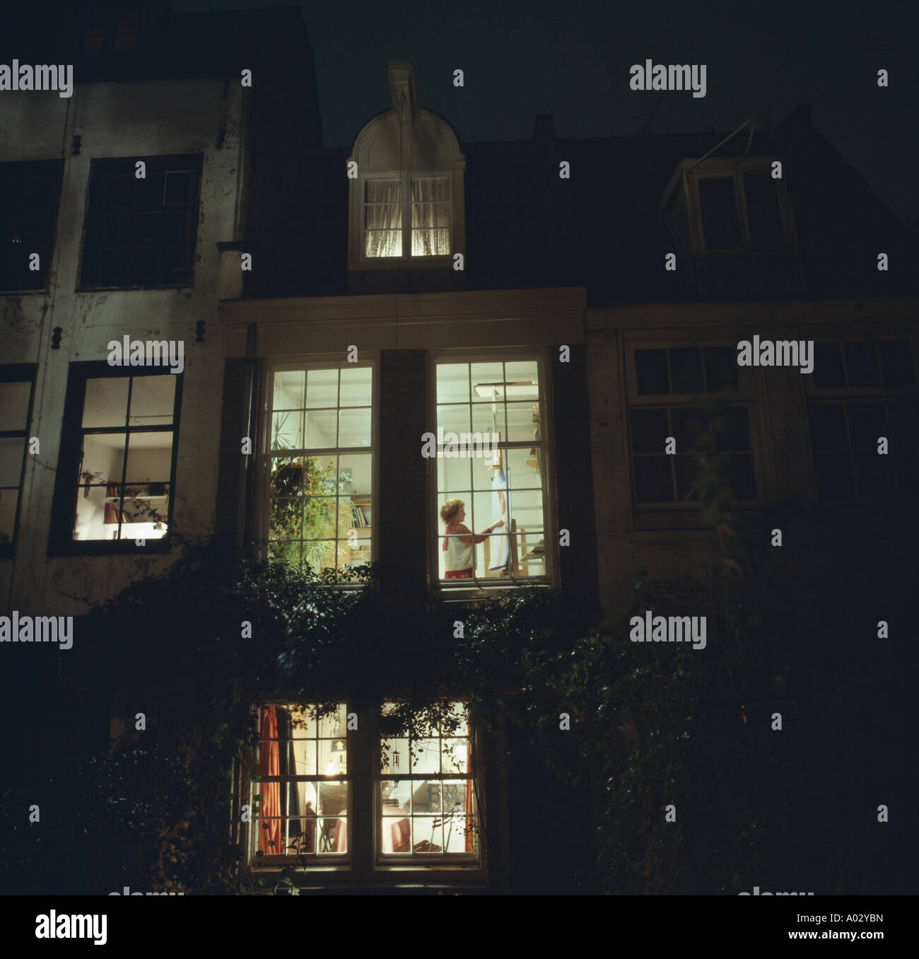 House in Amsterdam at night with lighted windows Stock Photo - Alamy