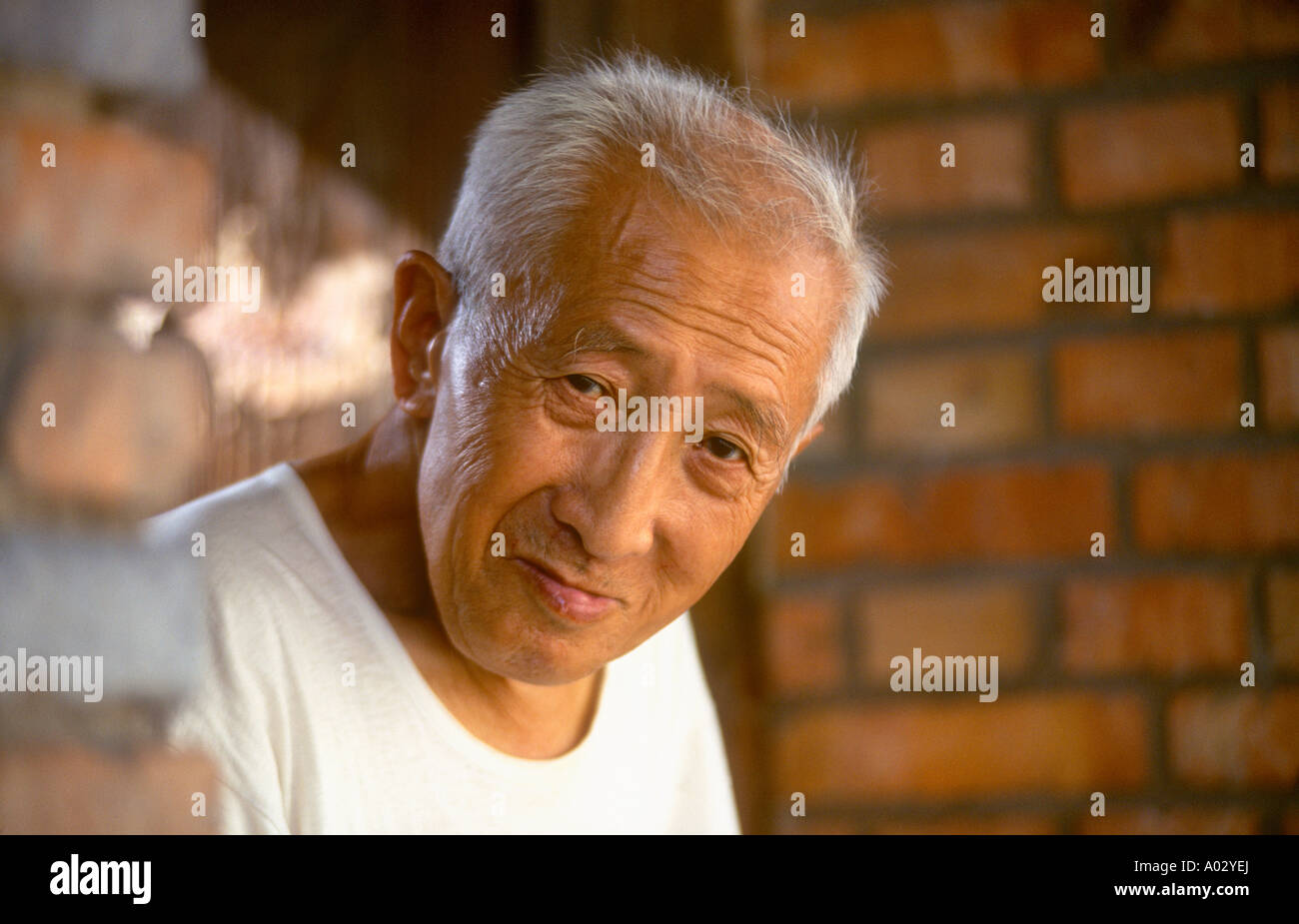 old chinese man at the front door of his house in the old parts of ...