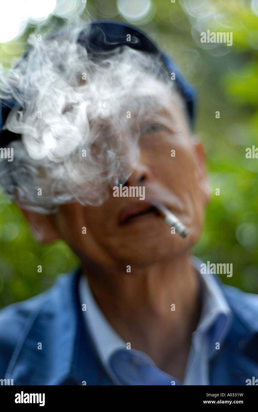 Elderly Chinese man smoking China Stock Photo - Alamy