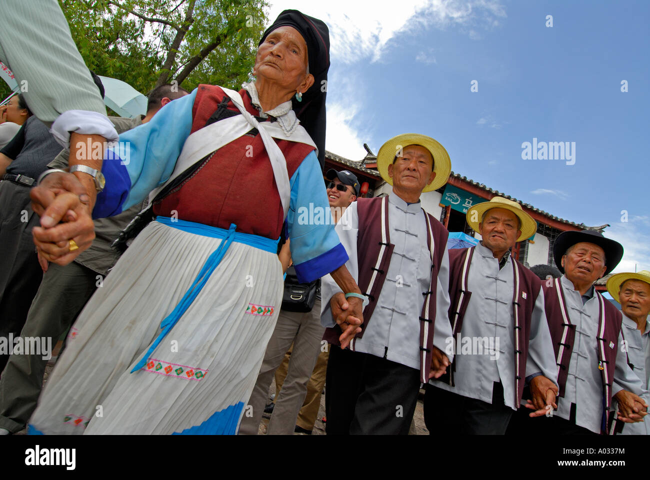 Old Naxi people dancing hand in hand on the Lijiang square Yunnan China ...
