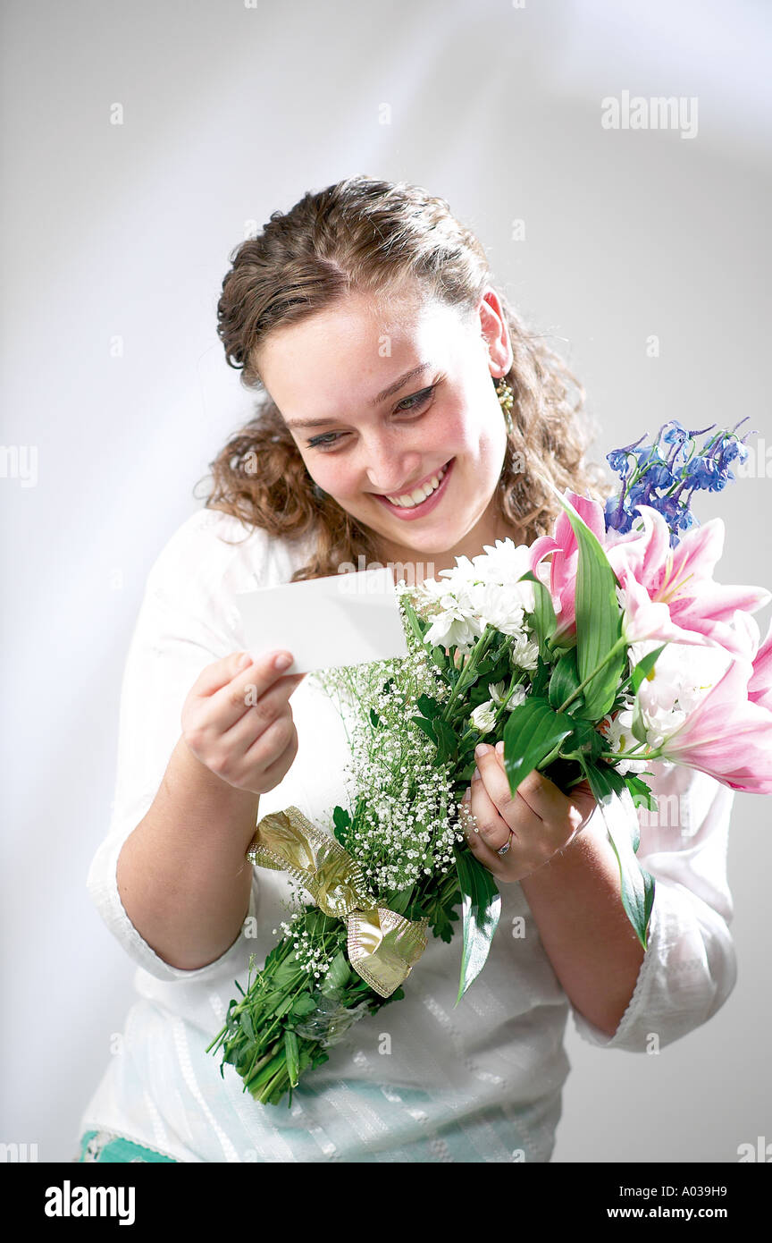 HAPPY SMILING YOUNG GIRL RECEIVES A GIFT OF FLOWERS WITH A CARD Stock ...