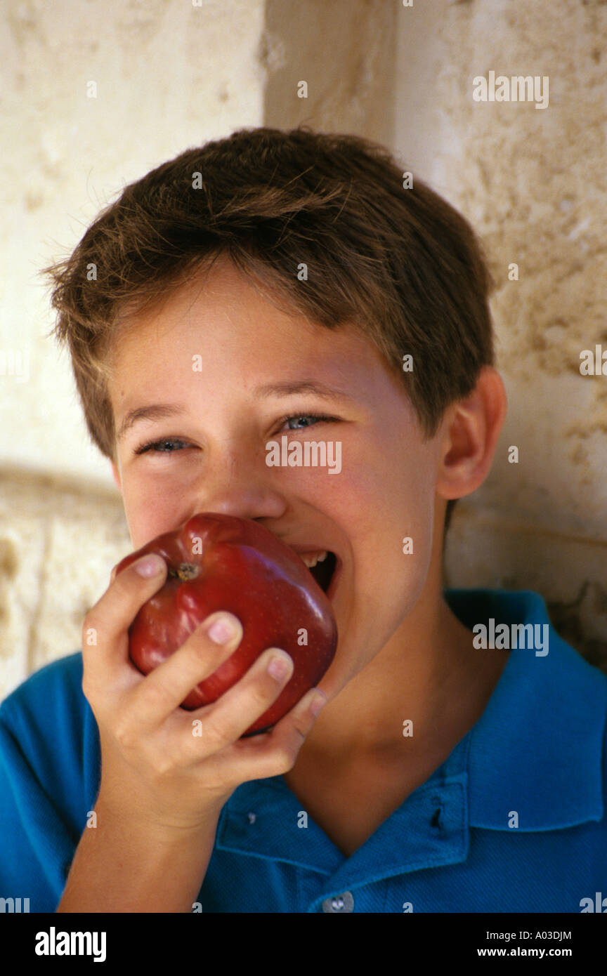 Model released boy eating red apple Stock Photo - Alamy
