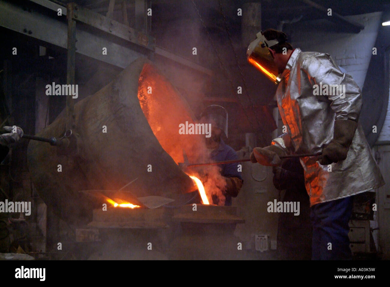 Casting a church bell.Molten metal pouring into a bell mould at ...