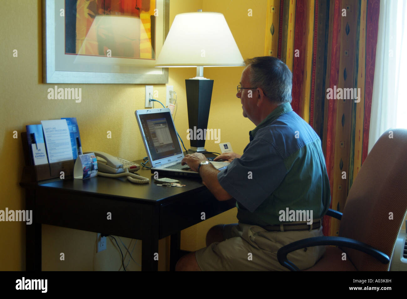 Businessman using a laptop computer on a desk in a hotel room Stock ...
