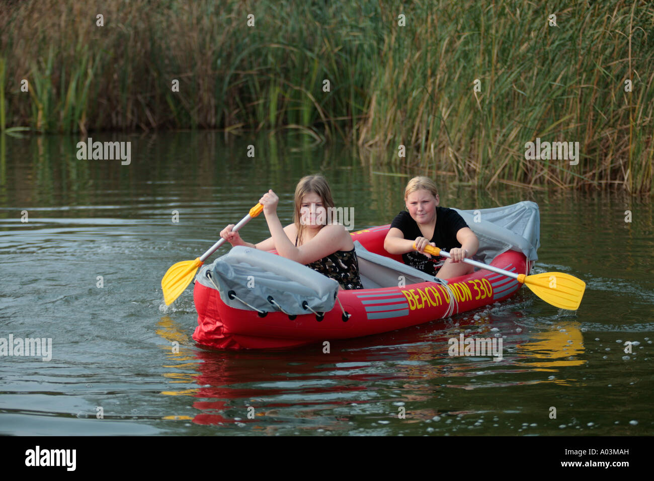 two girls in an inflatible boat on a lake Stock Photo - Alamy