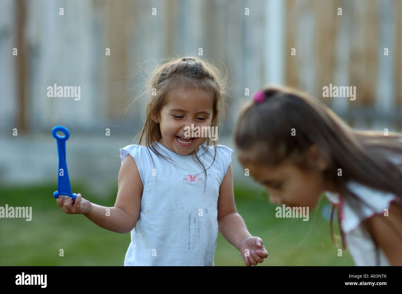 Cute girls playing outside and laughing Stock Photo - Alamy